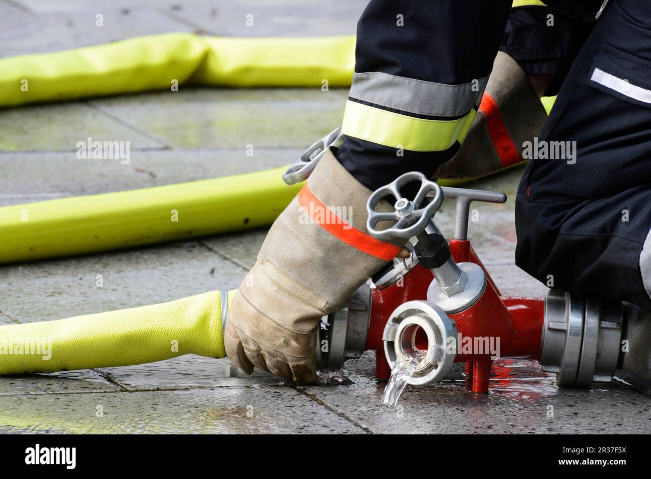 Hand of a fireman connection a firehose to a connector device Stock ...