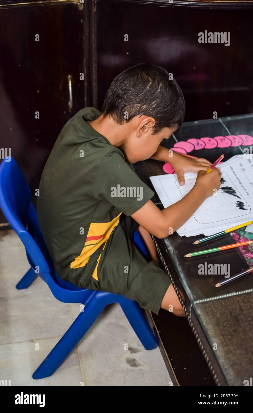 Smart Indian little boy drawing with colourful pencils kit of various ...