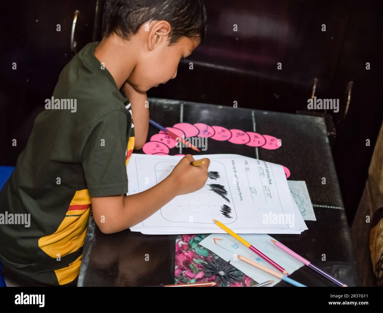 Smart Indian little boy drawing with colourful pencils kit of various ...