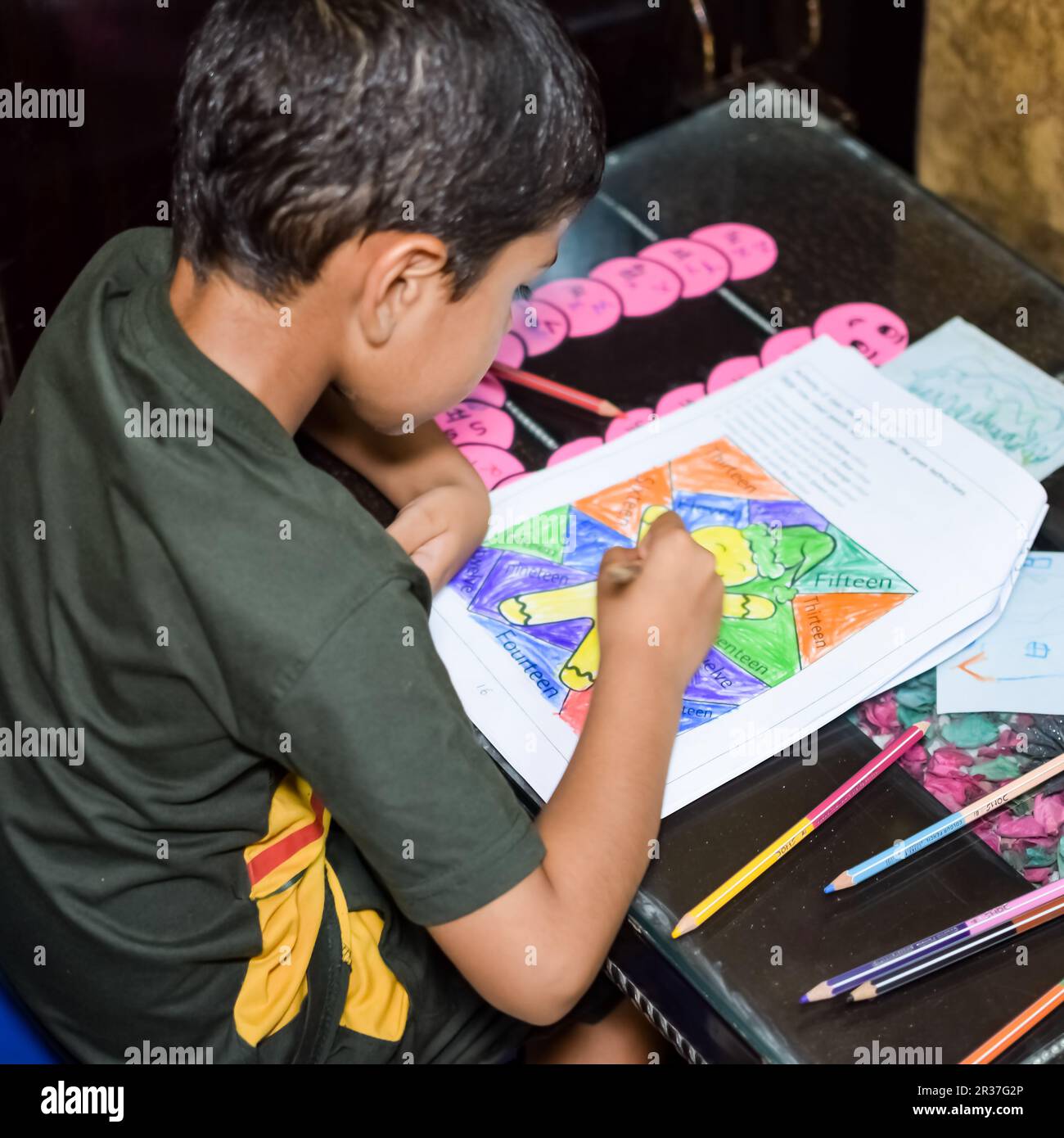 Smart Indian little boy drawing with colourful pencils kit of various ...