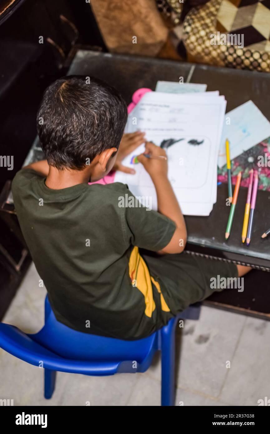 Smart Indian little boy drawing with colourful pencils kit of various ...