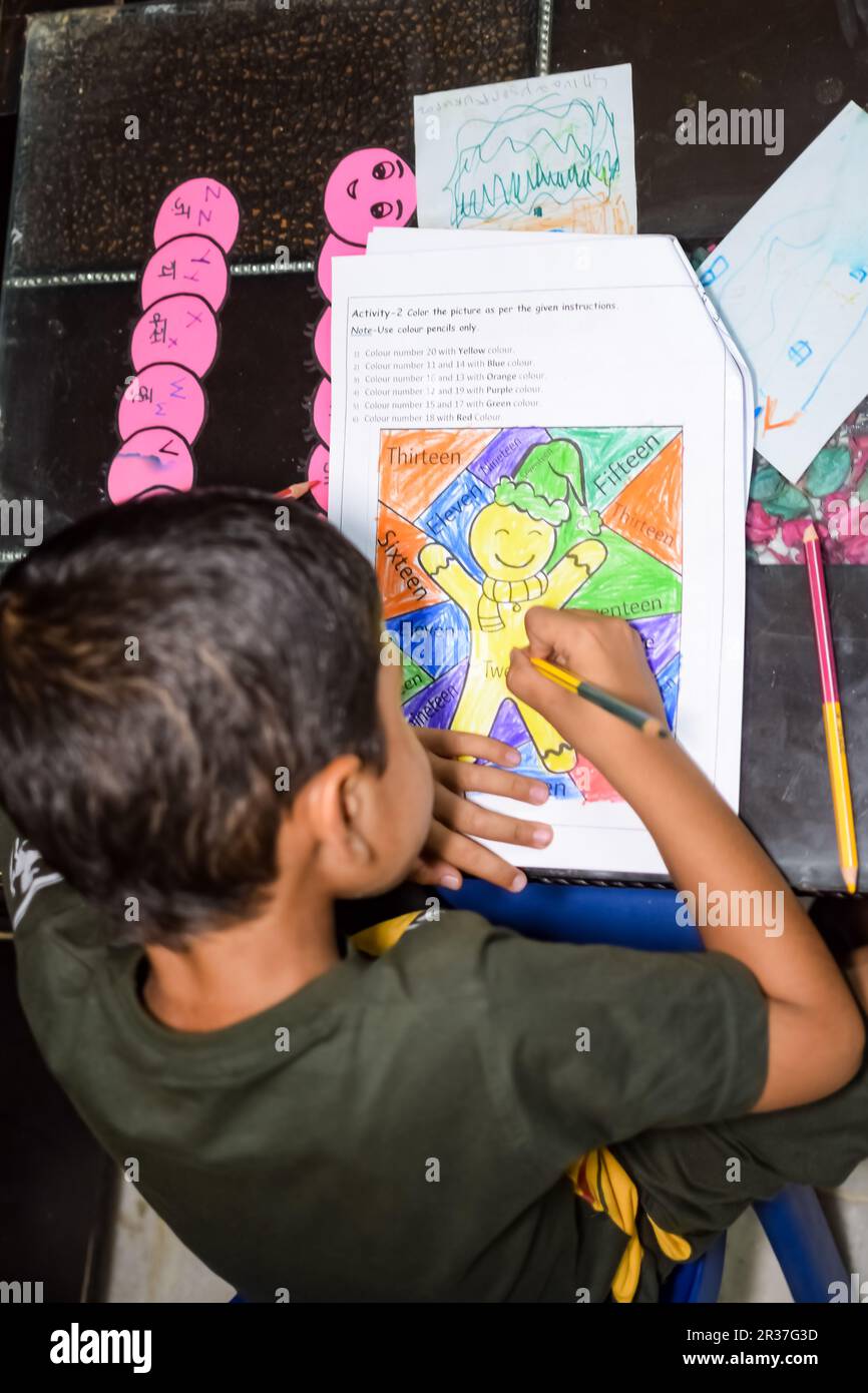 Smart Indian little boy drawing with colourful pencils kit of various ...