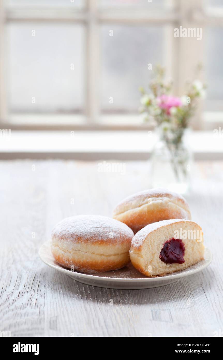 Jam doughnuts on a plate next to a window Stock Photo - Alamy