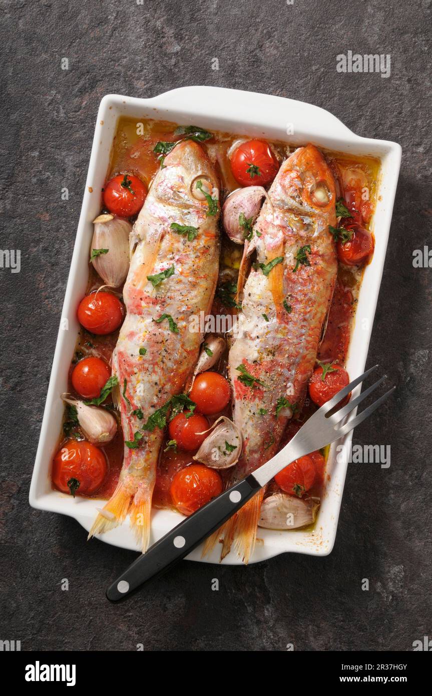 Red mullets stuffed with cherry tomatoes and garlic Stock Photo - Alamy