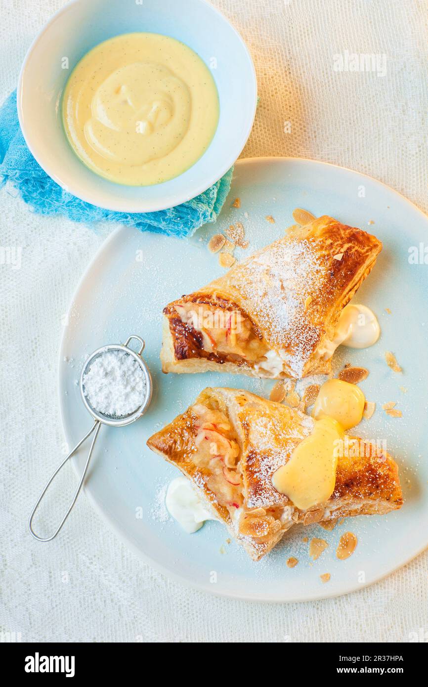 Apple and quark turnovers with icing sugar and custard Stock Photo - Alamy