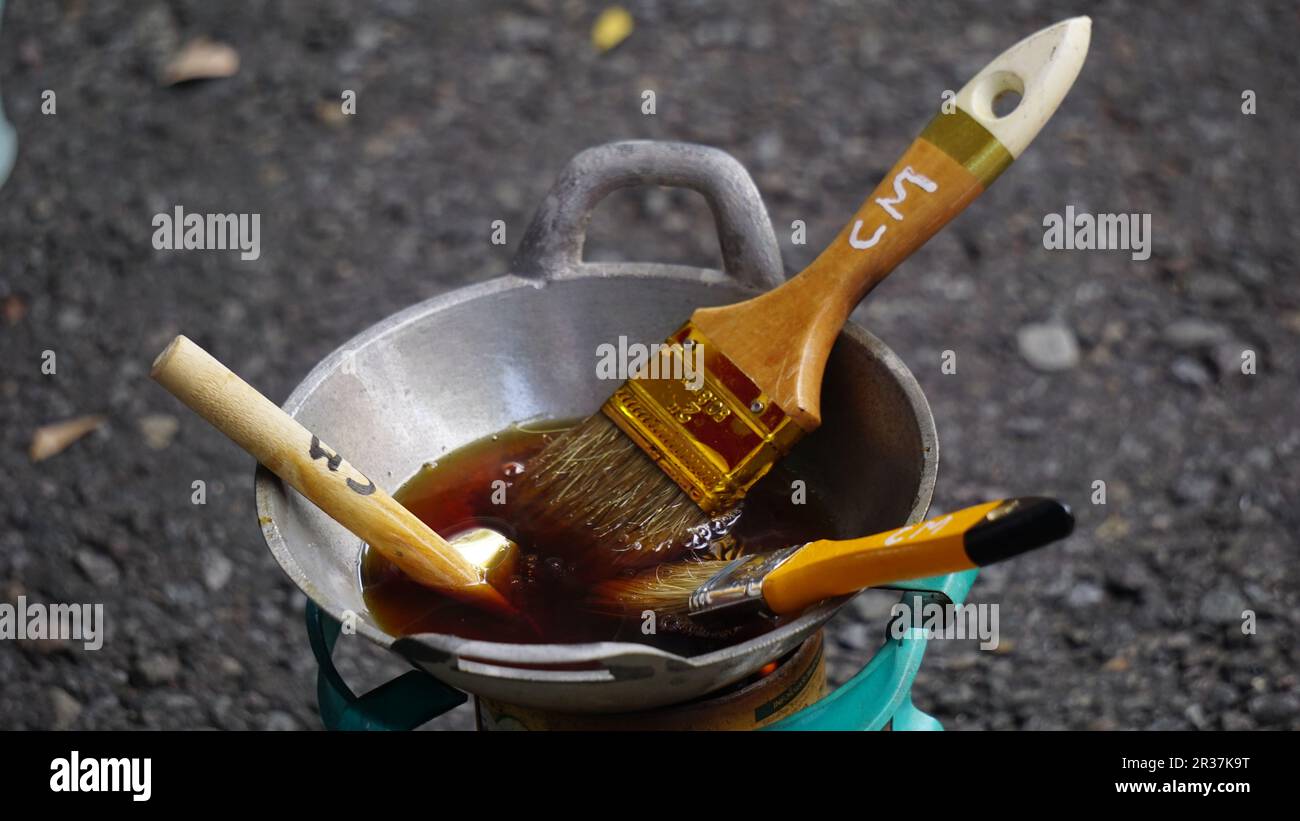 The wax (Indonesian call it malam) melts in the pan. This wax is used ...