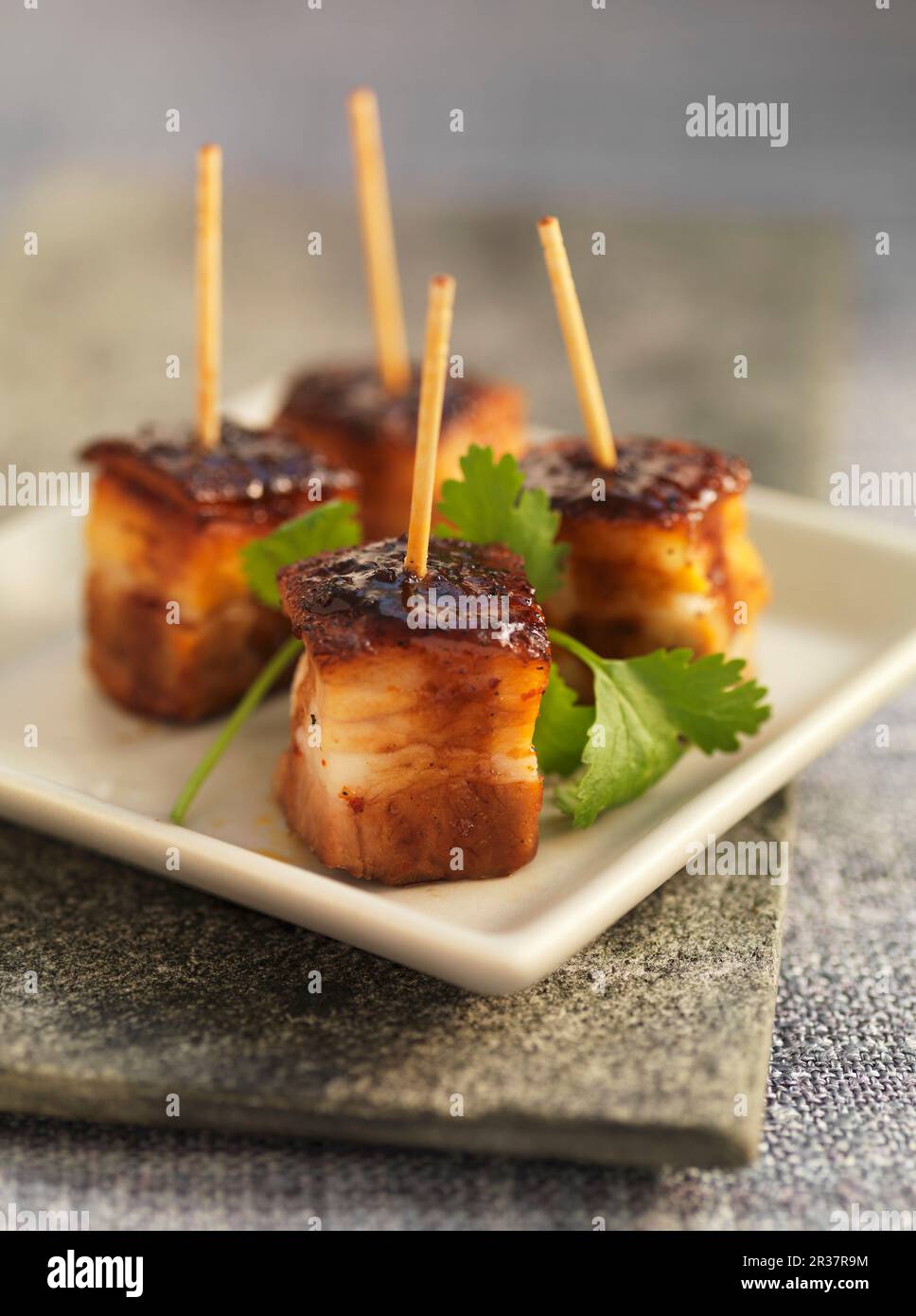 Crispy pork belly cubes on skewers Stock Photo - Alamy