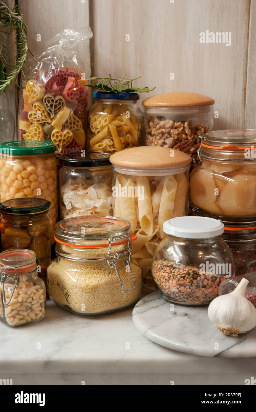 Still life arrangement in a pantry of storage jars of past, nuts, jams ...