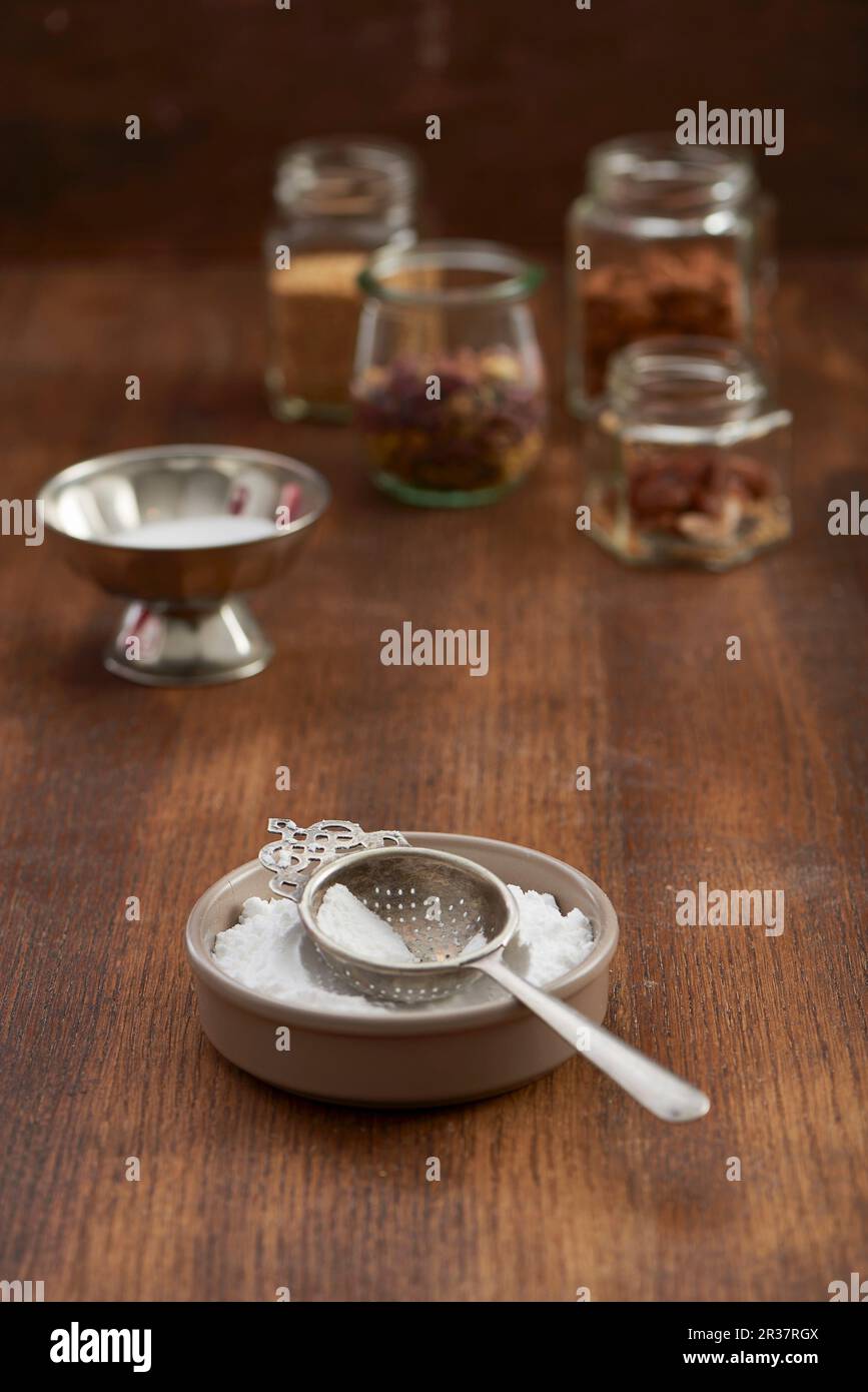 Icing sugar with a vintage sieve in a ceramic bowl Stock Photo - Alamy