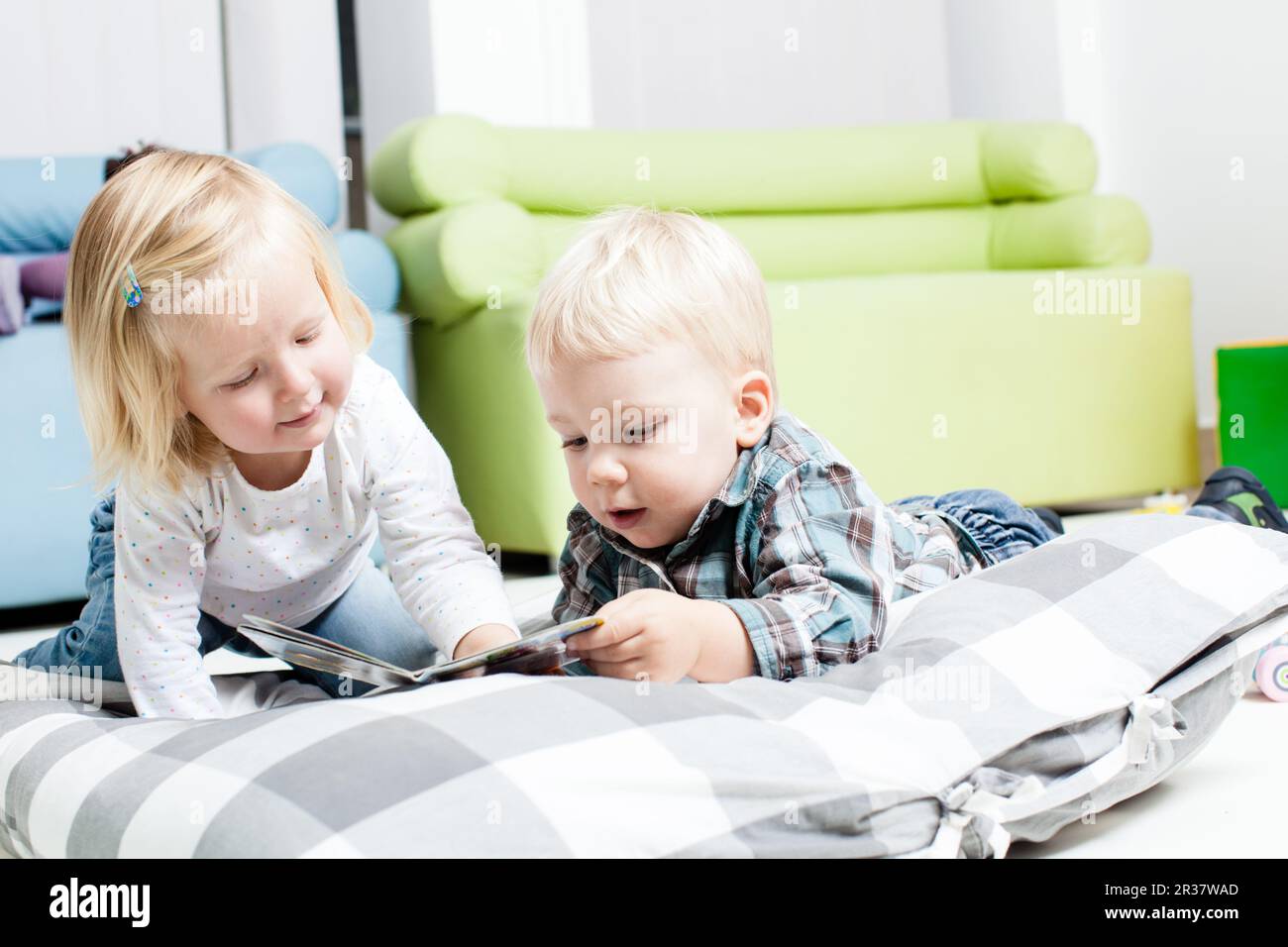 Cute kids review the book Stock Photo - Alamy