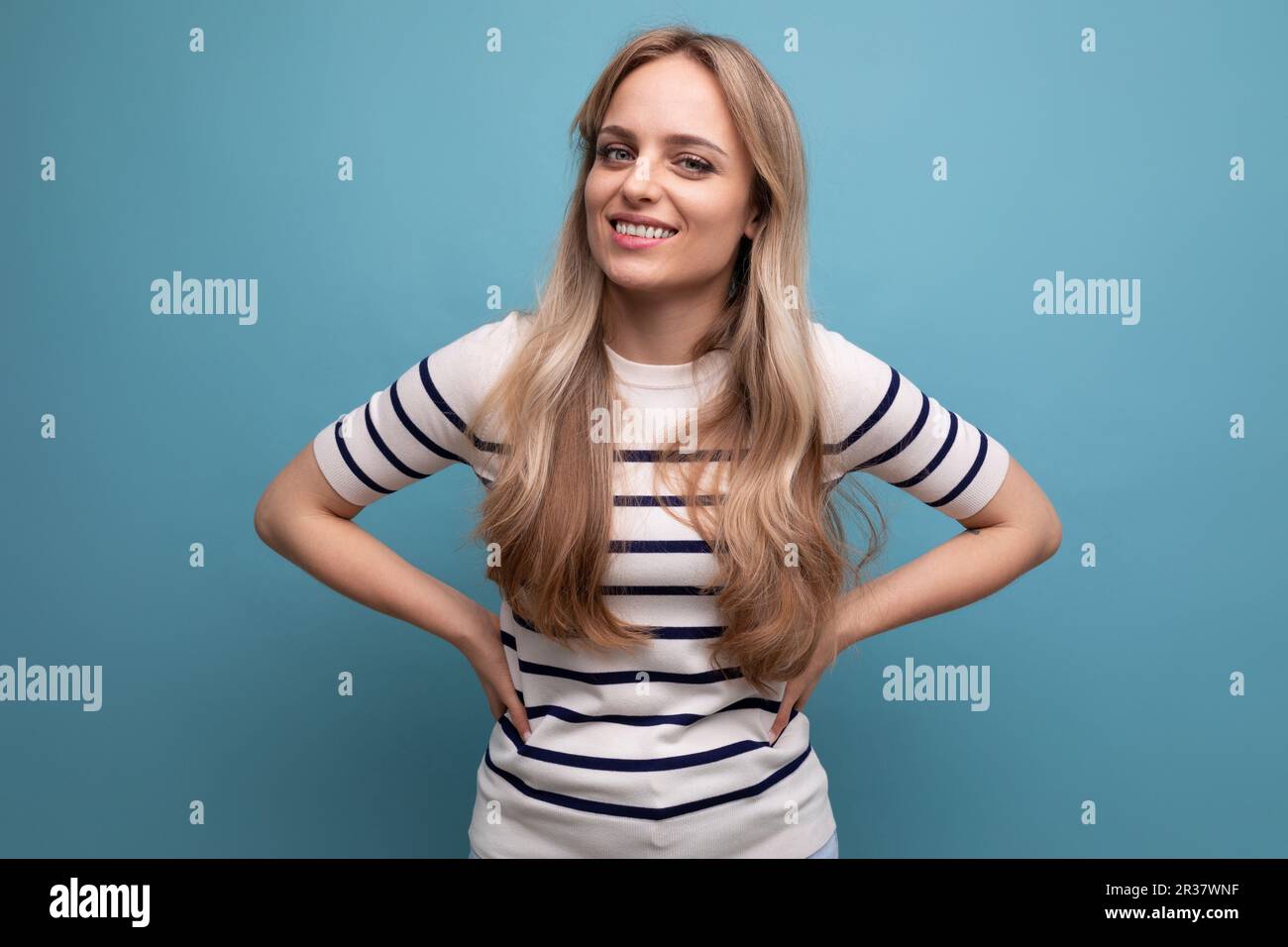 charming girl in casual clothes posing on a blue isolated background ...