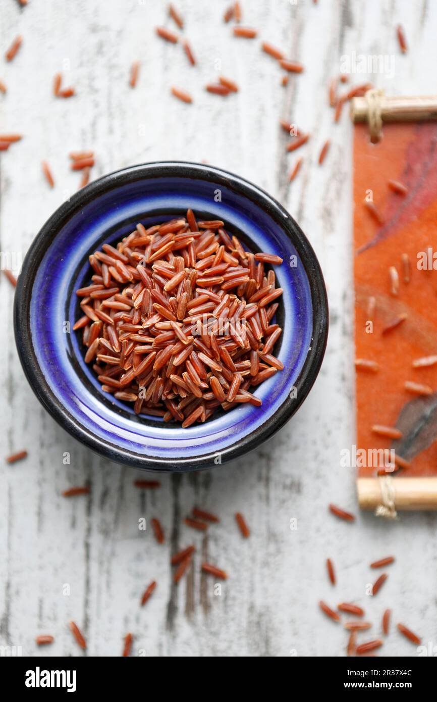 Red rice in a bowl on a colourful background (seen from above Stock ...