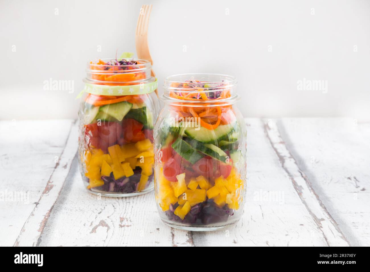 Rainbow salad in glass jars with red cabbage, yellow pepper, tomato ...