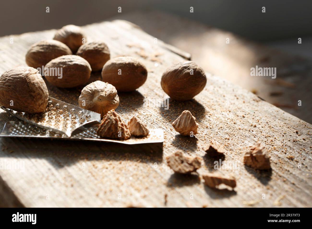 Whole and grated nutmegs and a nutmeg grater Stock Photo - Alamy