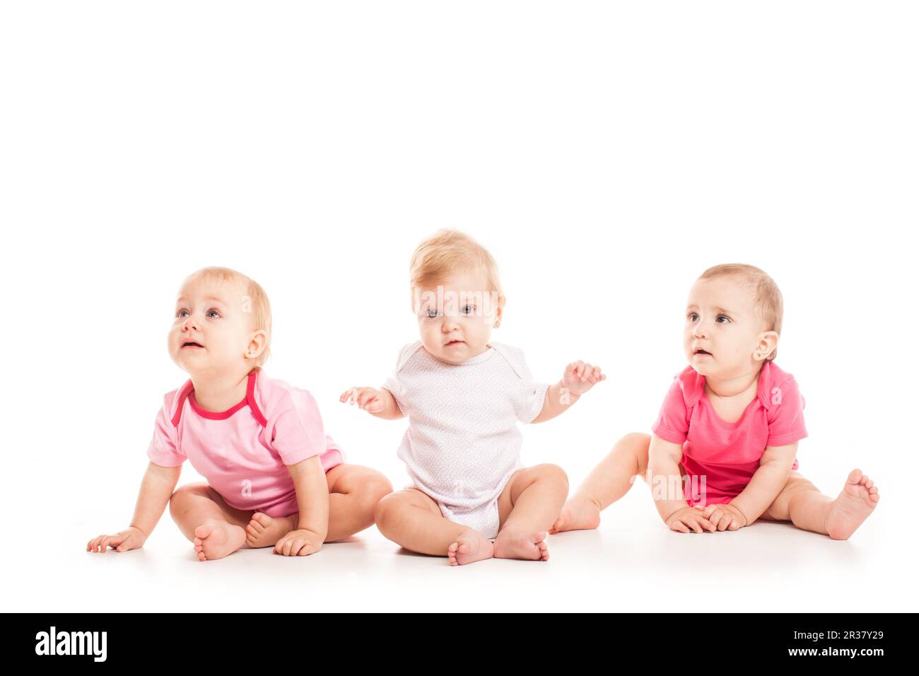 Three babies sitting Stock Photo - Alamy