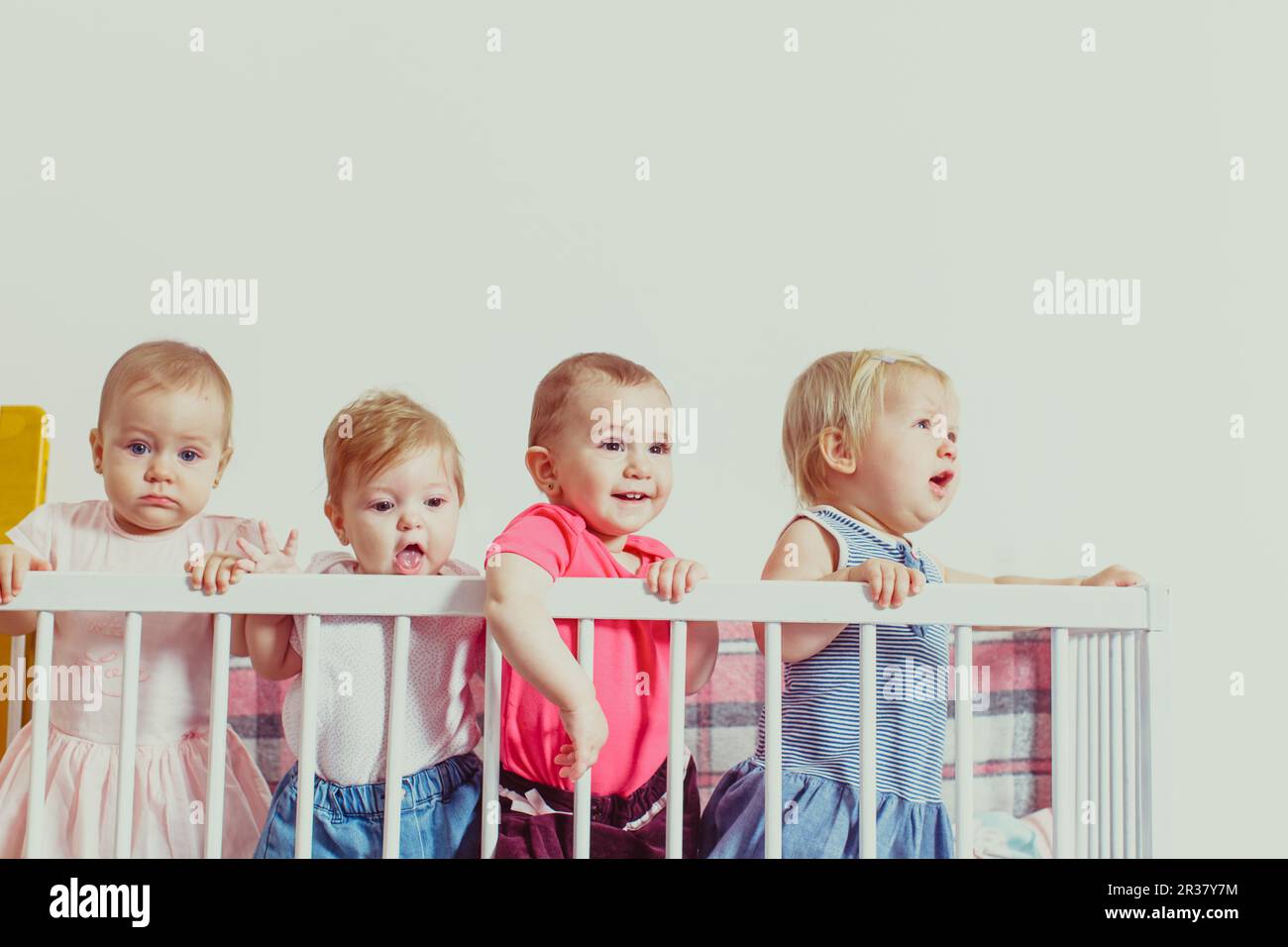 Three baby girls in the crib Stock Photo - Alamy
