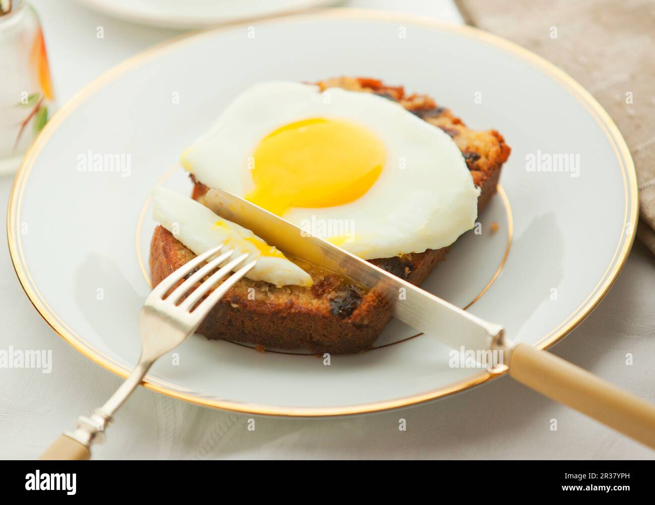 Poached egg on banana bread cut with a knife and fiork Stock Photo - Alamy