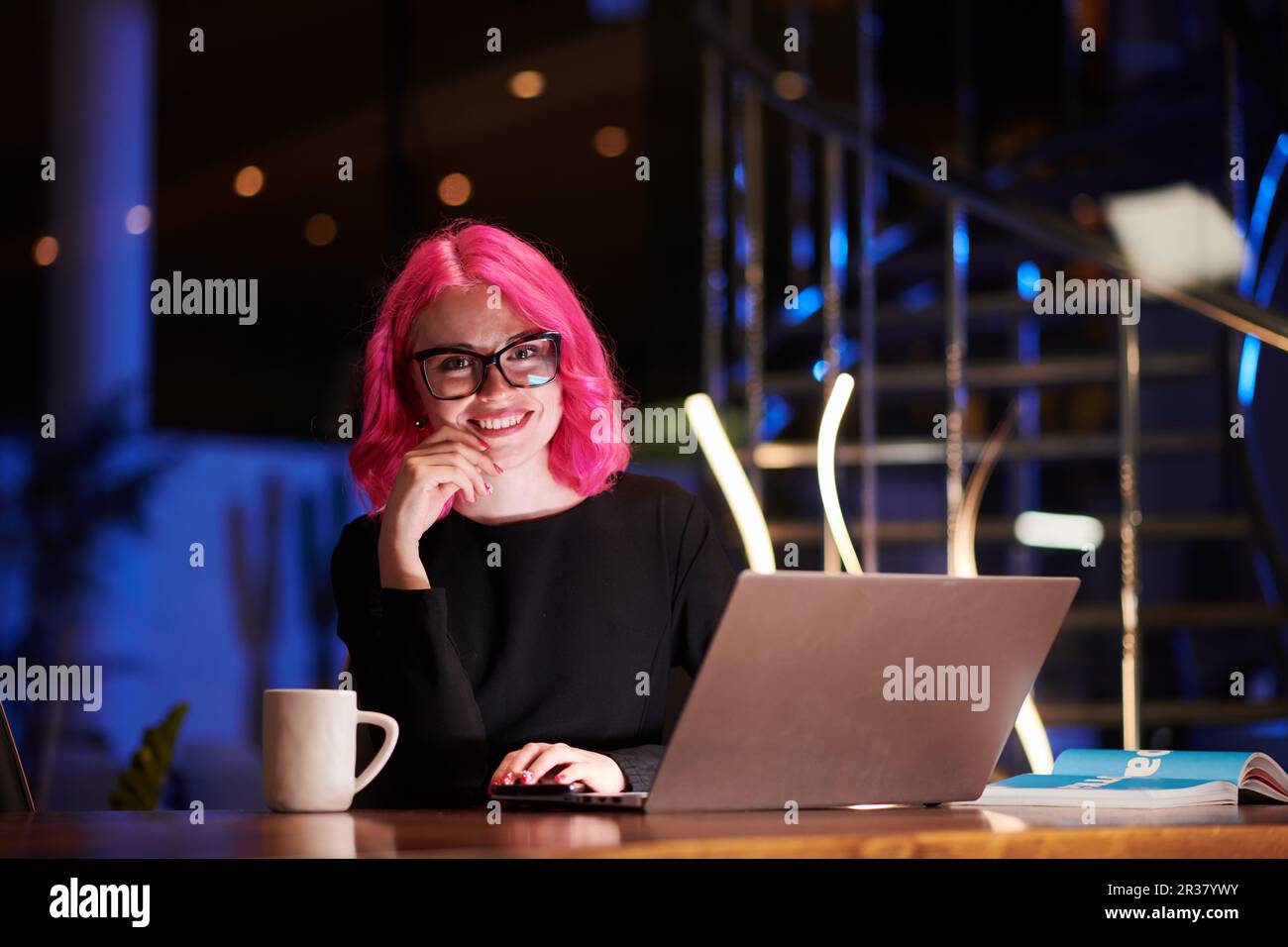 Smiling night club owner working on laptop at bar counter Stock Photo ...