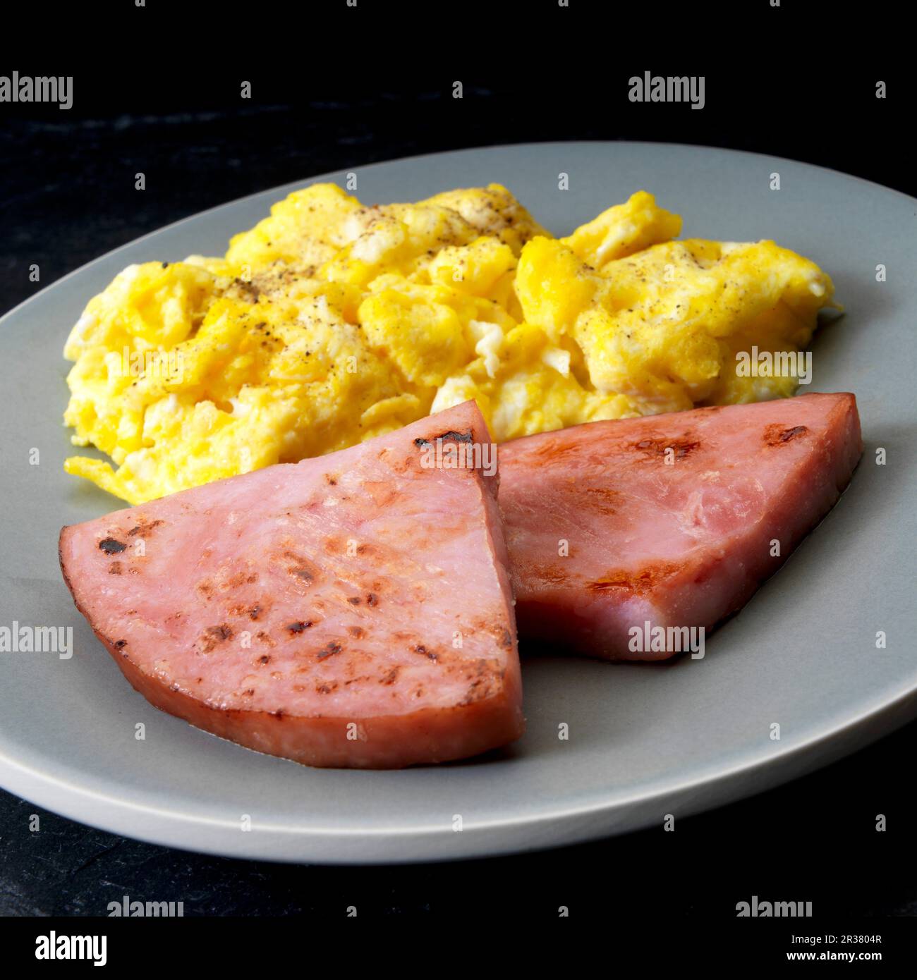 Fried breakfast ham with scrambled eggs Stock Photo - Alamy