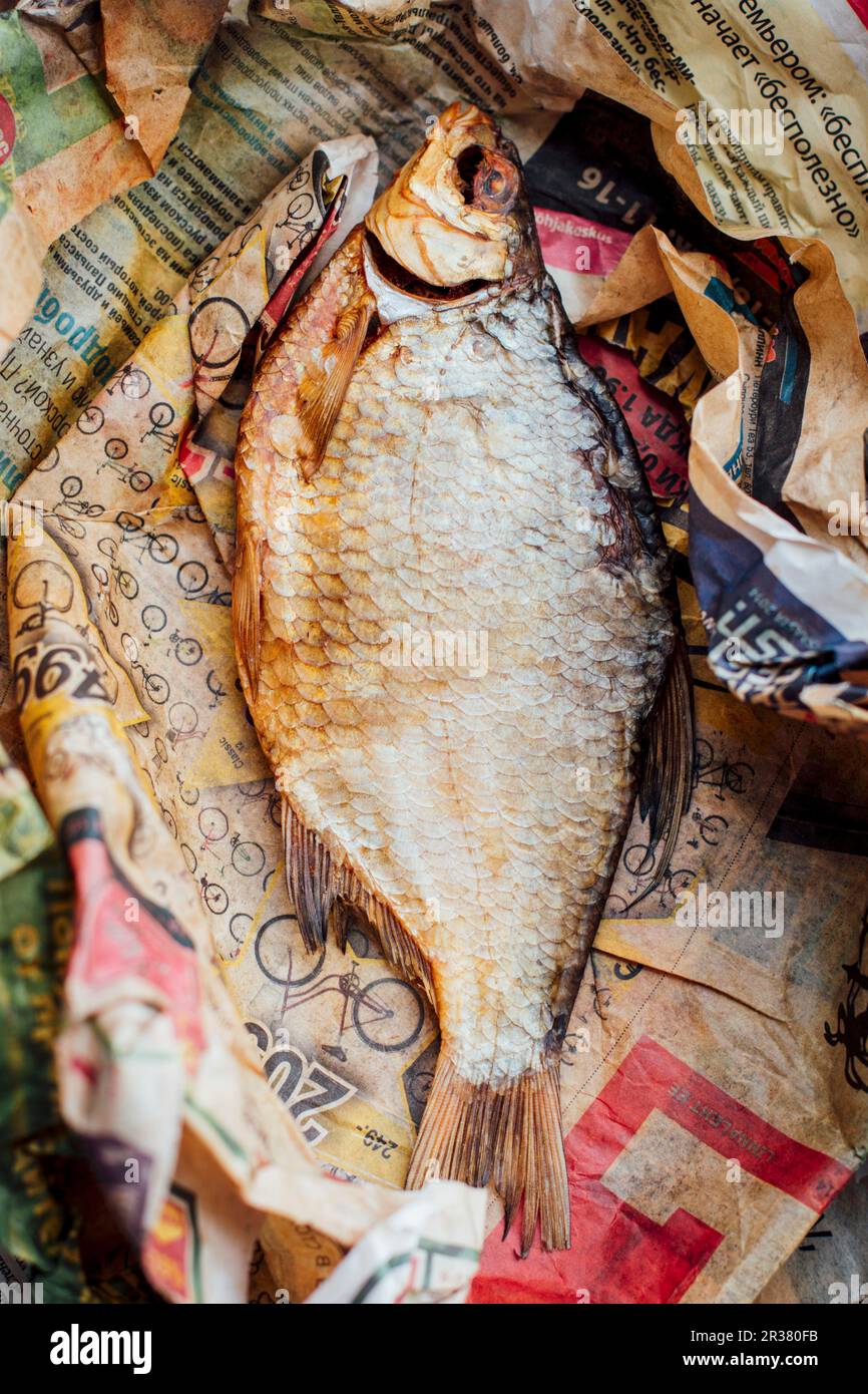 A dried fish in an old newspaper Stock Photo - Alamy