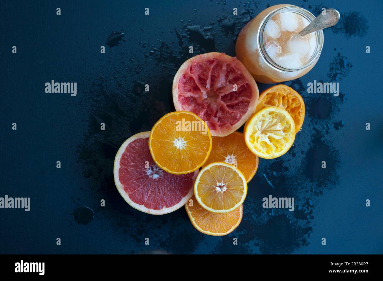Citrus fruits, some with the juice squeezed out, and a glass of juice ...