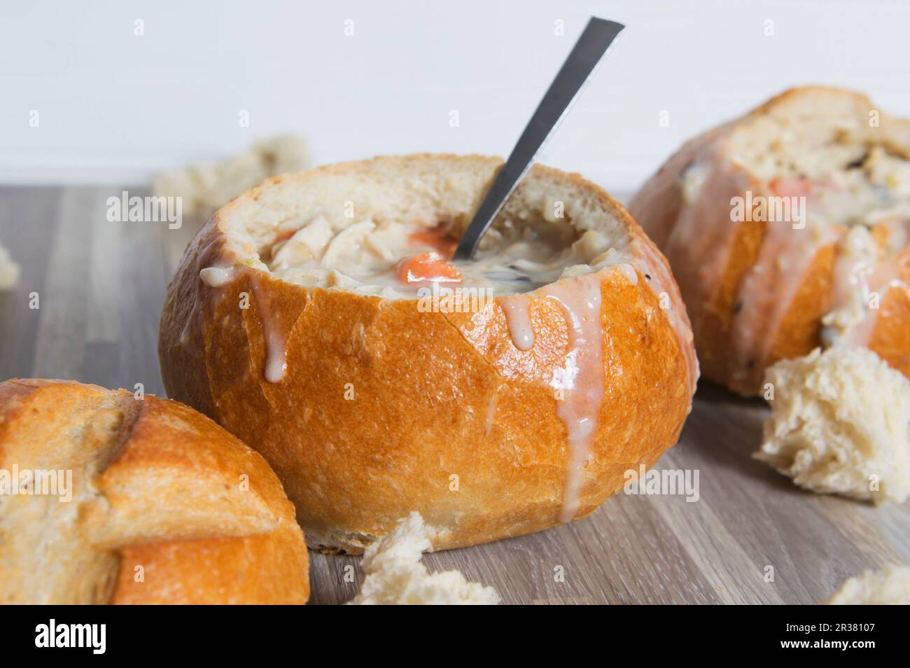 Creamy chicken soup with wild rice served in hollowed-out bread rolls ...