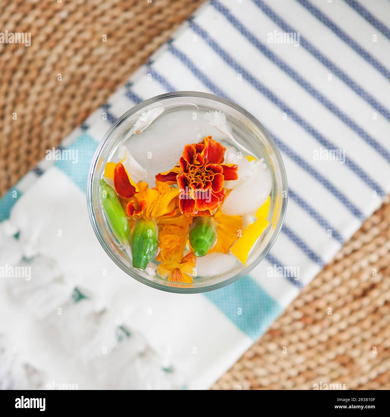 Mineral water in a glass infused with melon and edible flowers (top ...