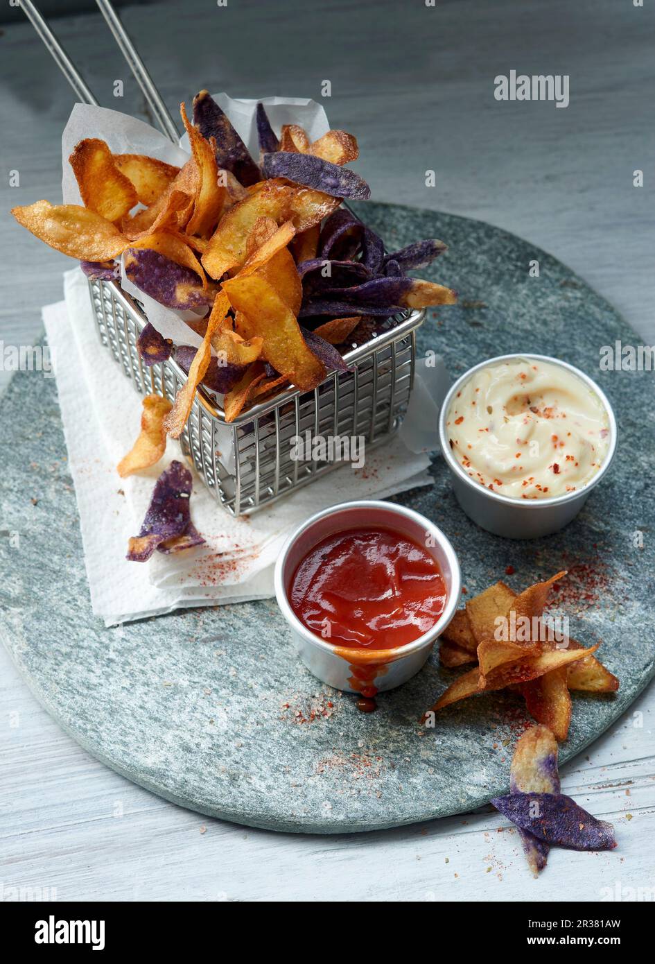 Colourful potato crisps with ketchup and chilli mayonnaise Stock Photo ...