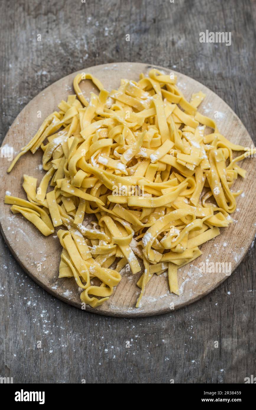 Homemade ribbon noodles on a wooden plate Stock Photo - Alamy