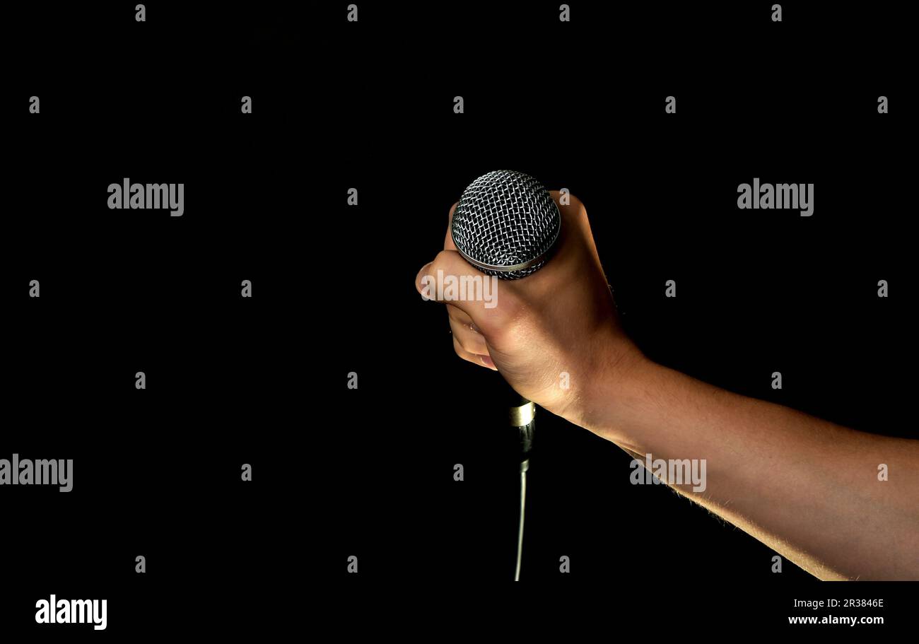Male hand with microphone isolated on black Stock Photo - Alamy