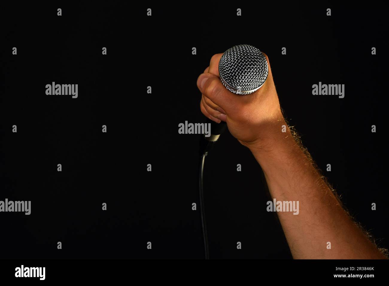 Male hand with microphone isolated on black Stock Photo - Alamy