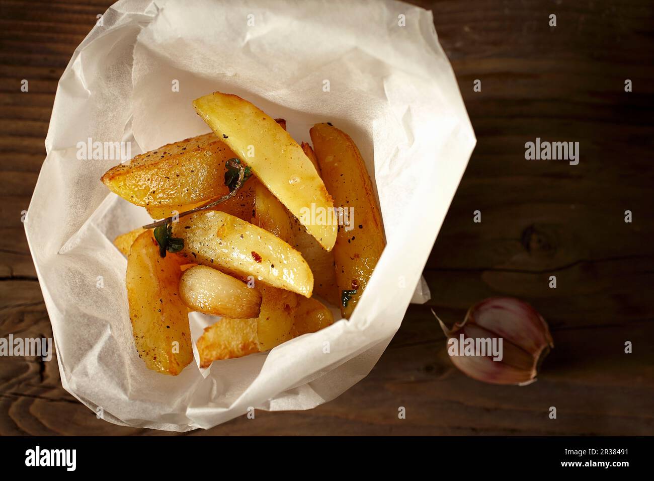 Homemade potato wedges in paper with garlic Stock Photo - Alamy