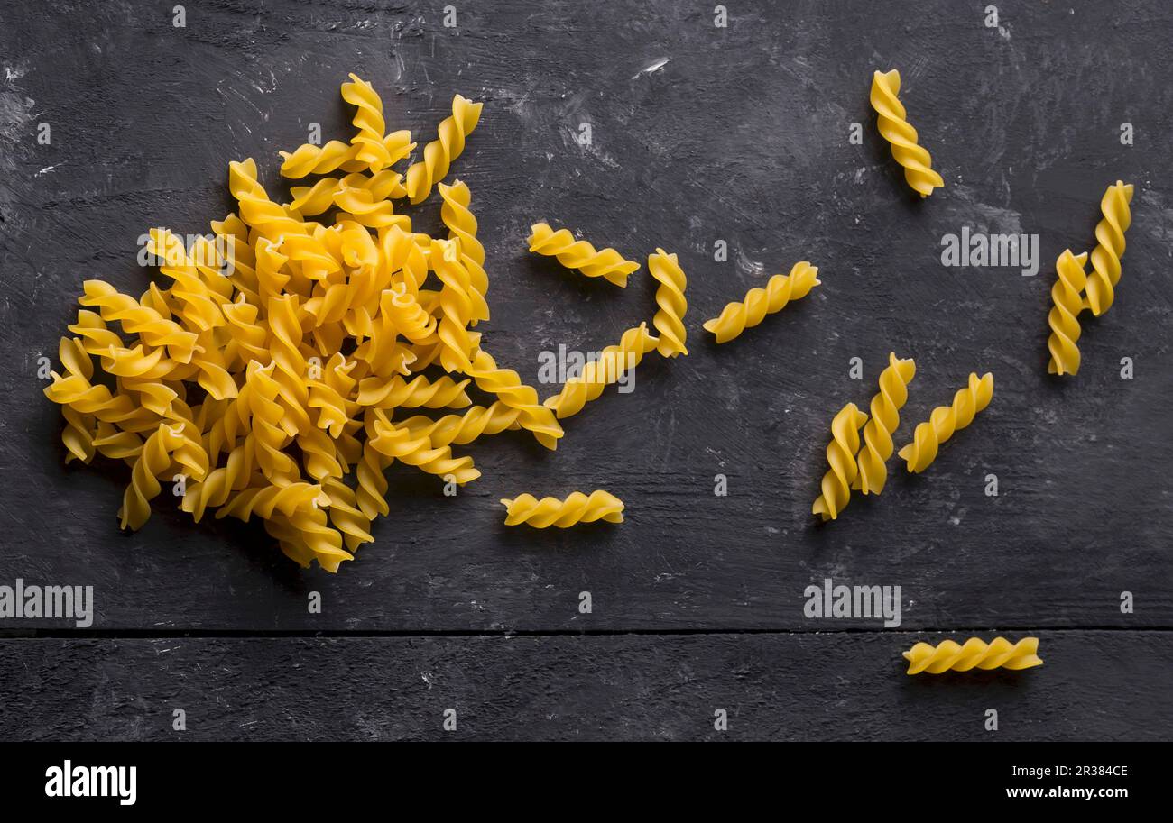 Dried spirelli pasta on a black background Stock Photo - Alamy