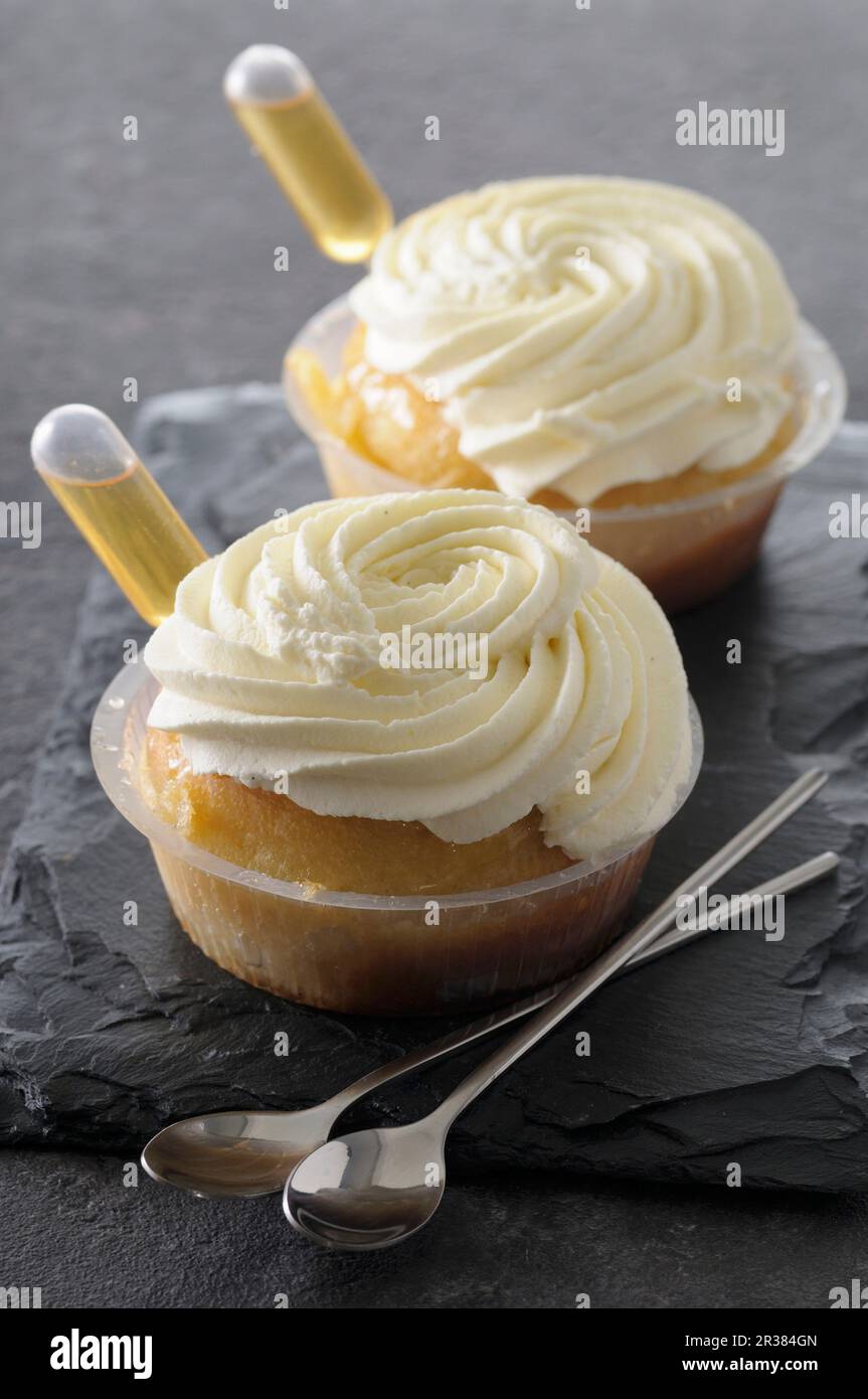 Rum baba with cream in plastic bowls Stock Photo - Alamy