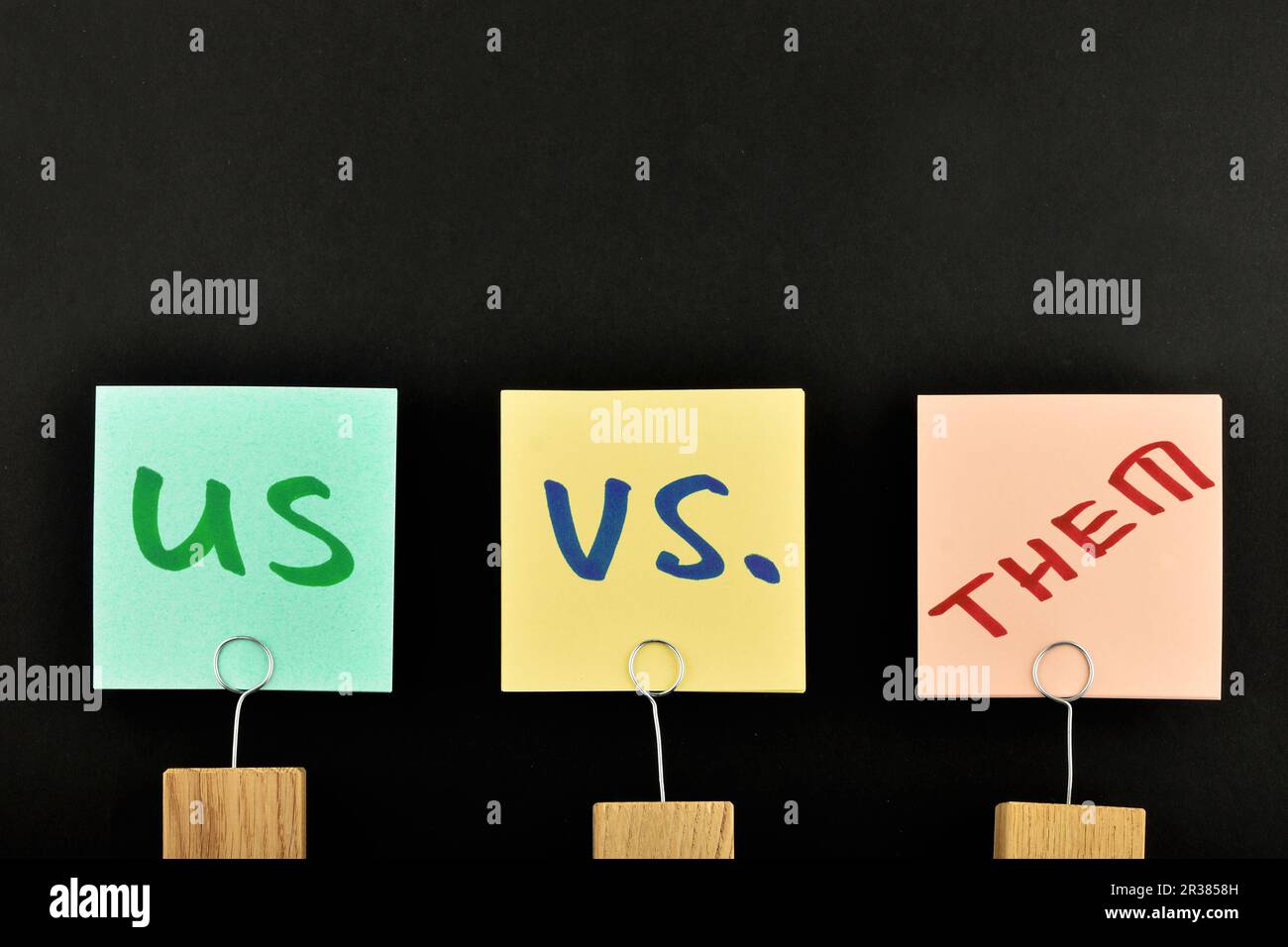 Us vs them three paper notes isolated on black Stock Photo - Alamy