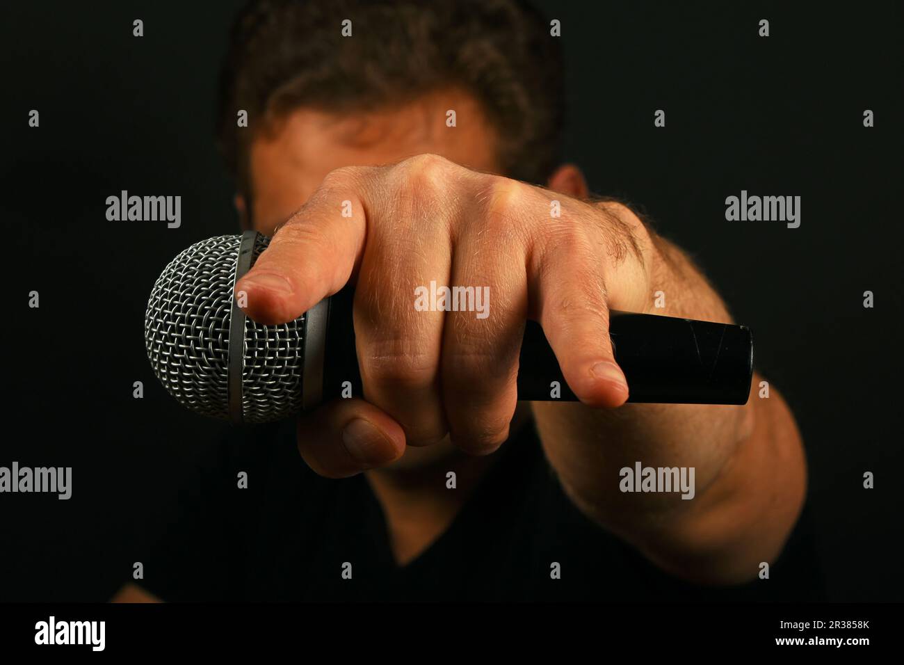 Hand with microphone and devil horns on black Stock Photo - Alamy