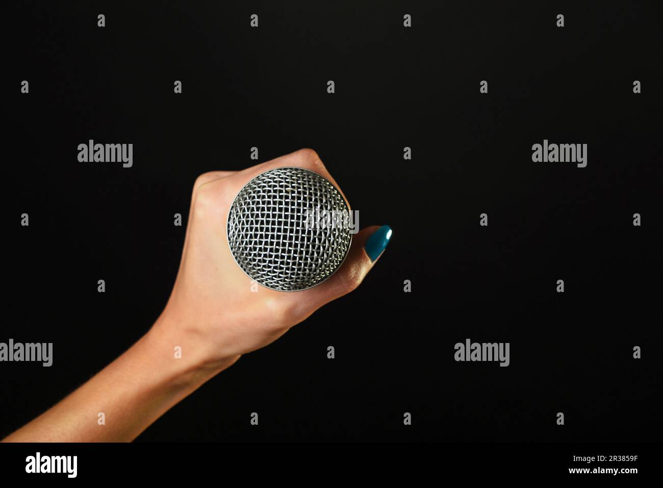 Woman hand with microphone isolated on black Stock Photo - Alamy