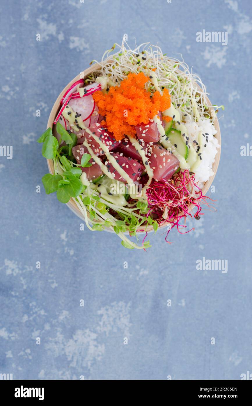 A Poke bowl with tuna, sushi rice, tobiko, radishes, cucumber slices ...