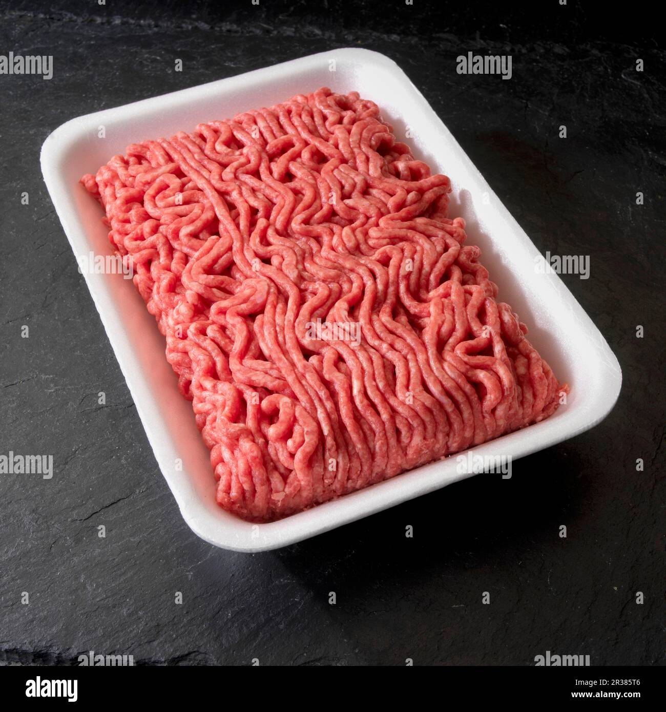 Ground beef in white tray on black background Stock Photo - Alamy
