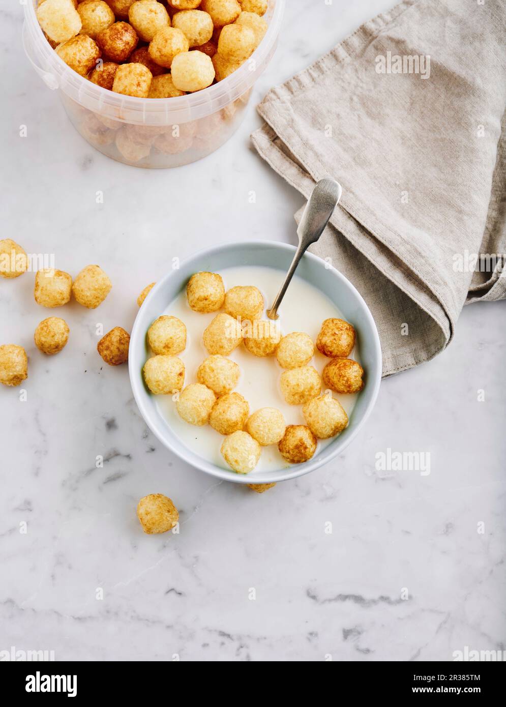 Corn pops in a plastic tub and in a bowl with milk Stock Photo - Alamy