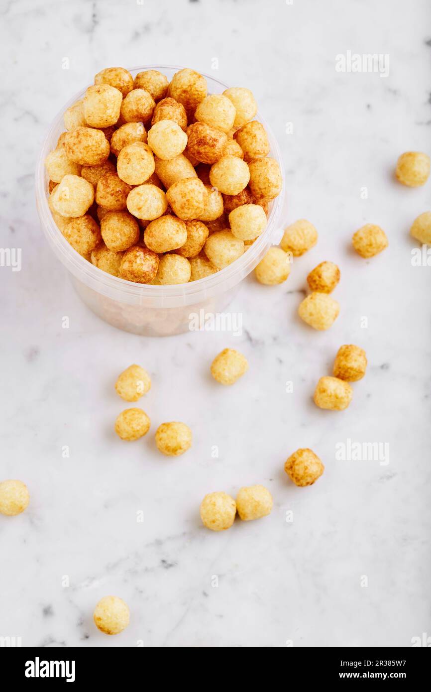 Corn pops in a plastic tub and on a marble background Stock Photo - Alamy