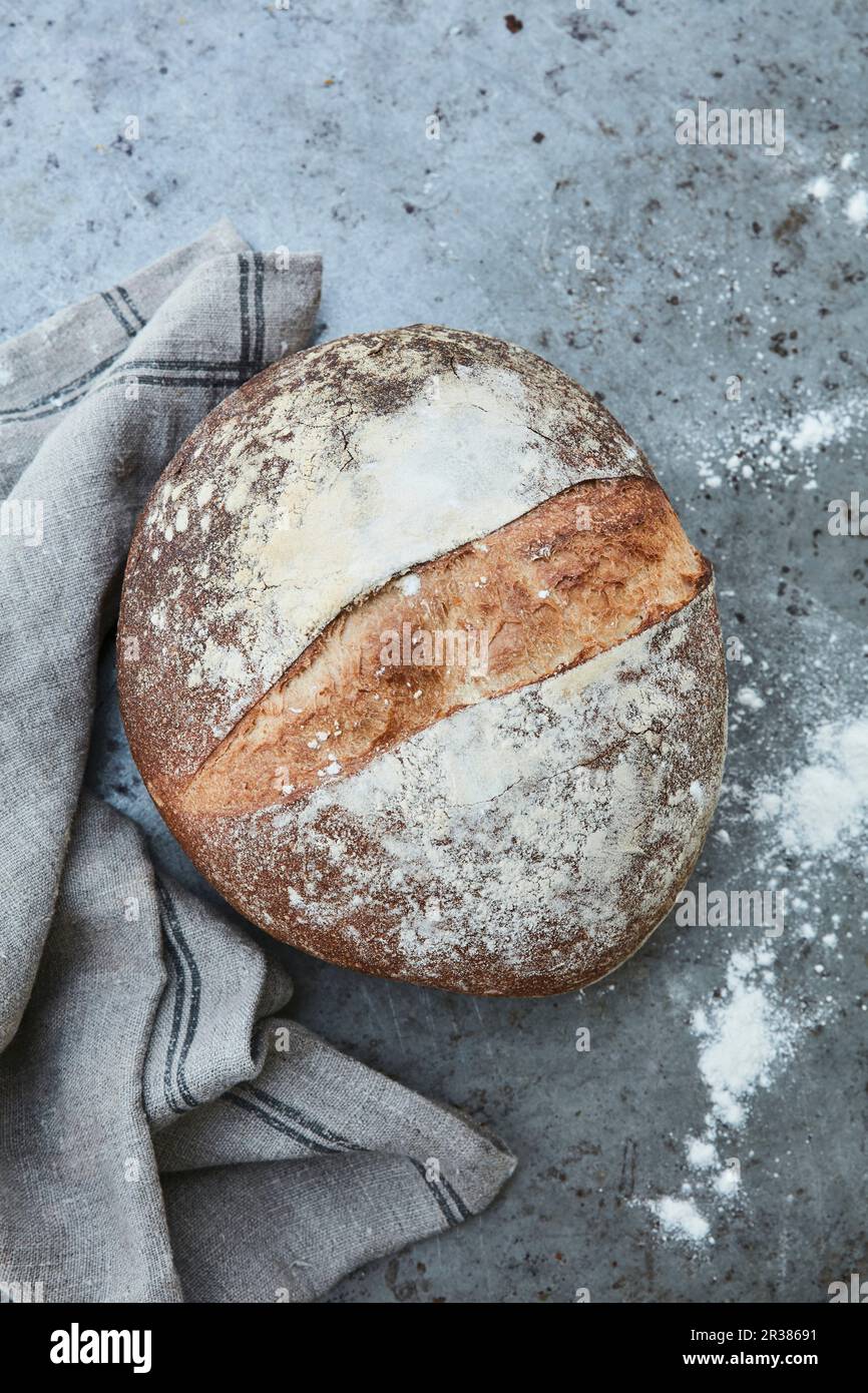 A loaf of bread with a linen cloth on a stone floor (top view Stock ...
