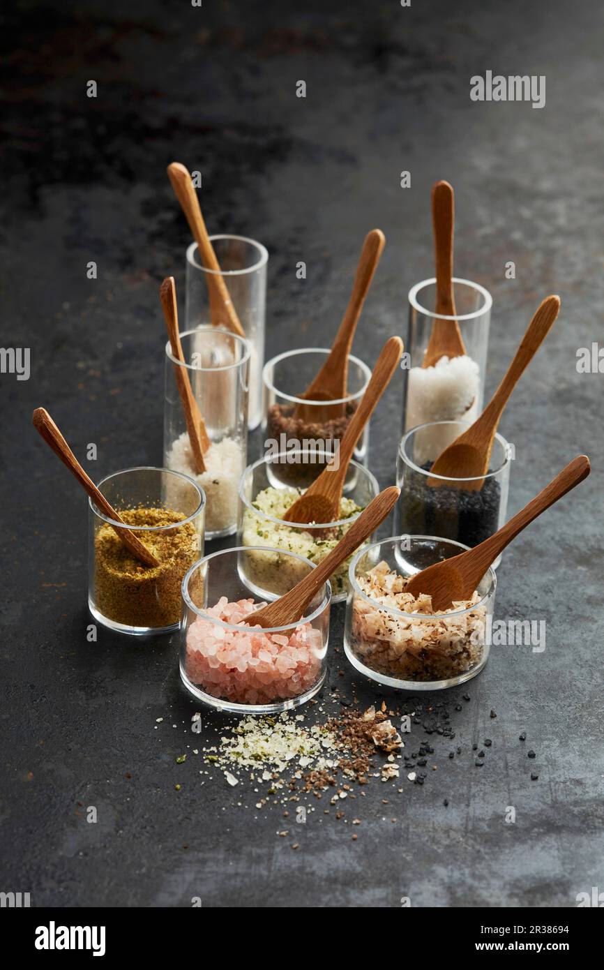 A still life of different salt varieties in glass jars with wooden ...