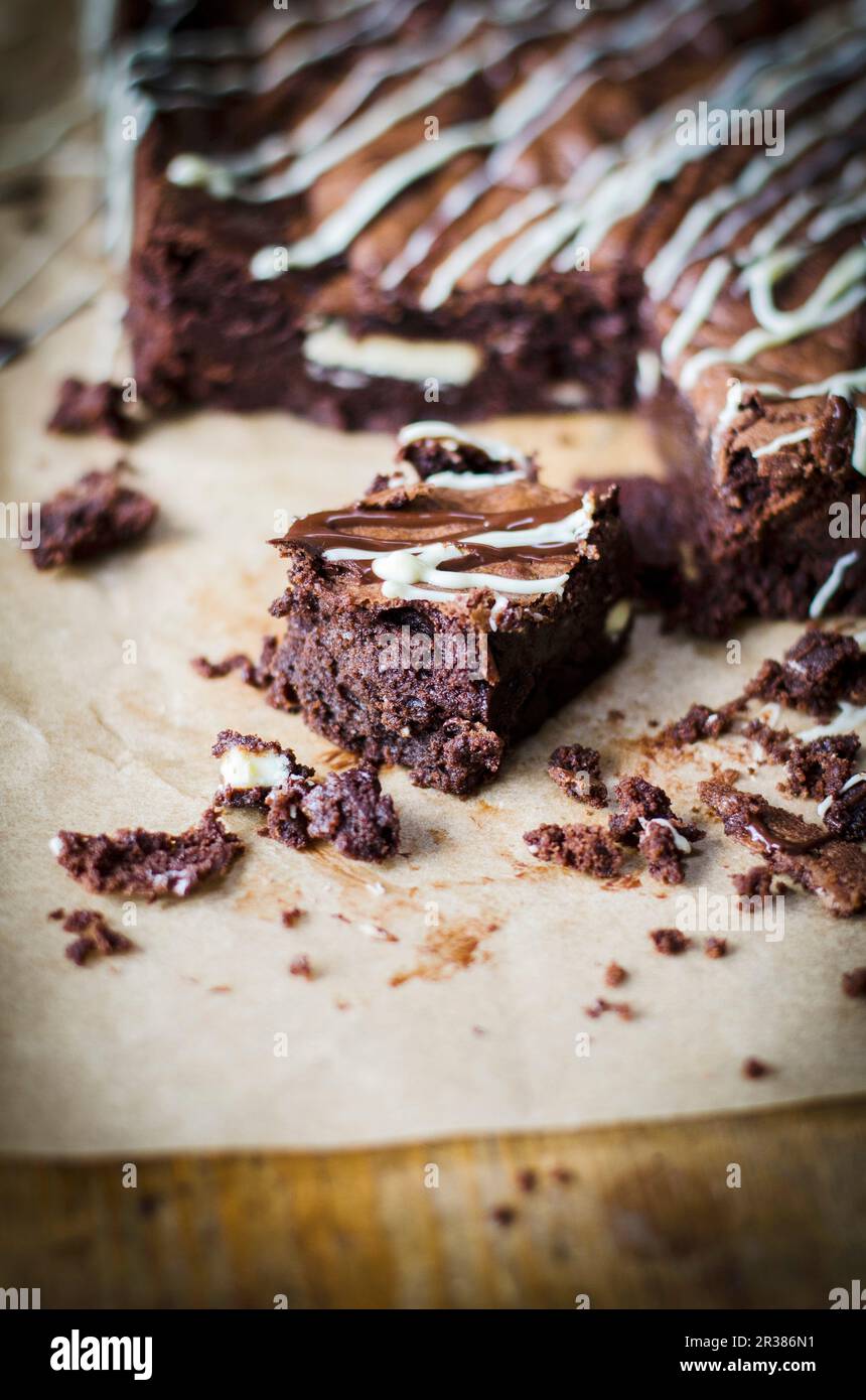 Chocolate brownie with dark and white drizzle Stock Photo - Alamy