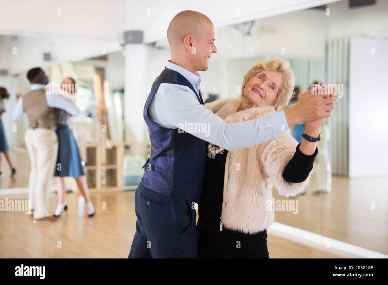 Elderly woman learning ballroom dancing movements in pair Stock Photo ...