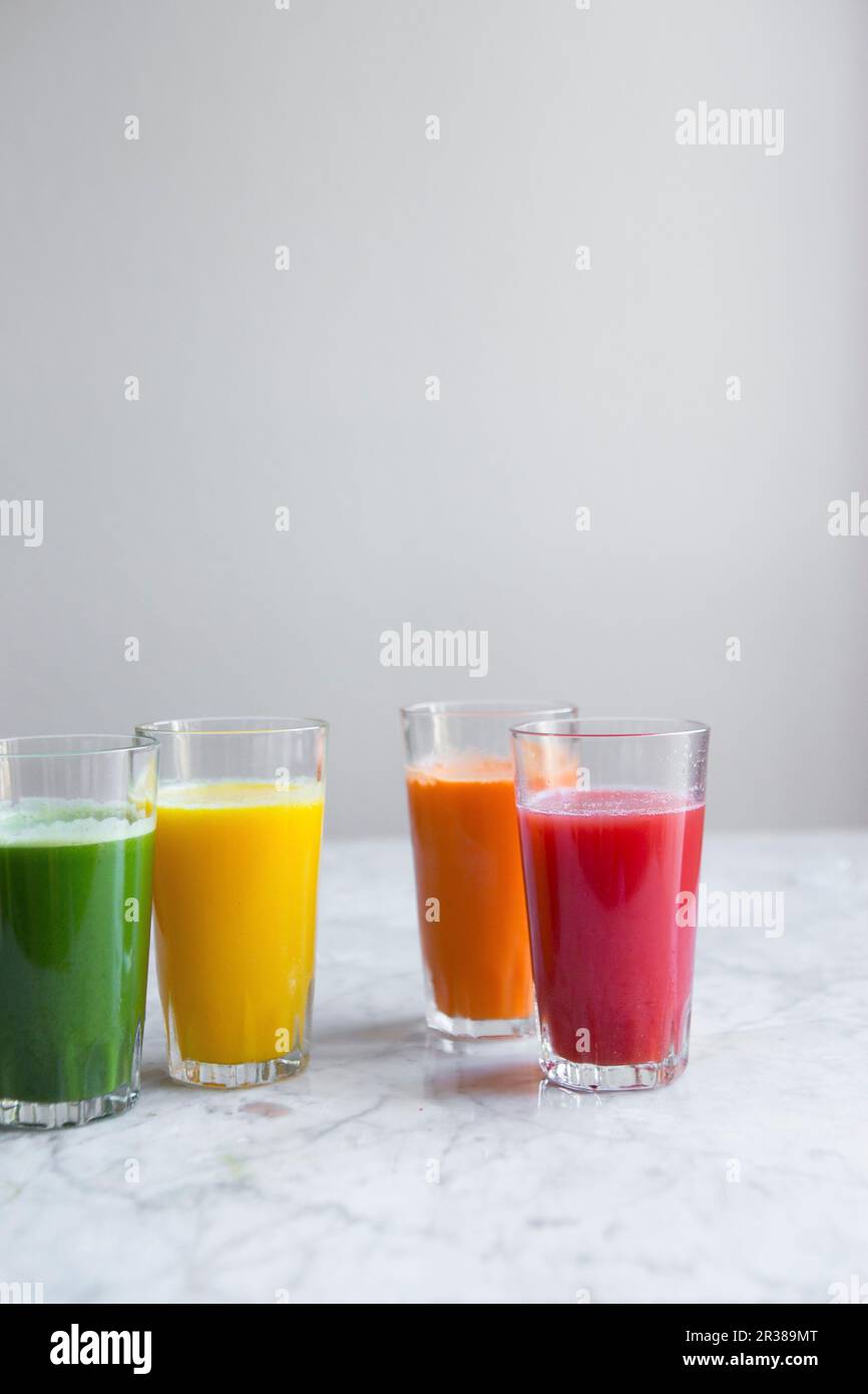 Various fresh cold-pressed juices (green juice, apple and lemon juice ...