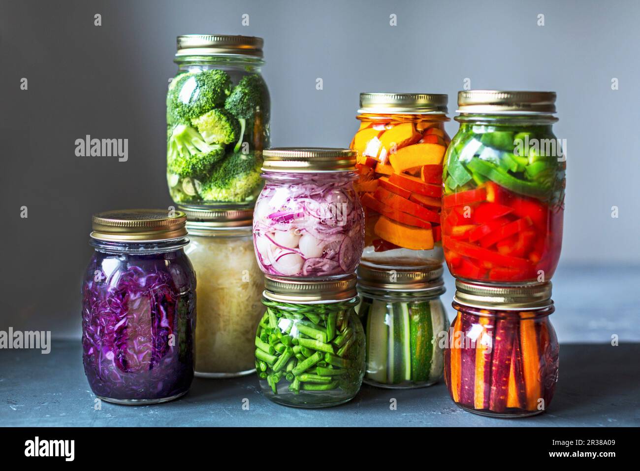 Stacked preserving jars of freshly pickled vegetables in front of a ...