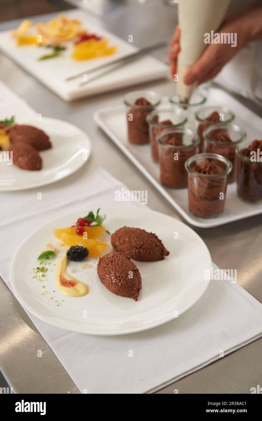 Chocolate mousse being piped into small glass jars Stock Photo - Alamy