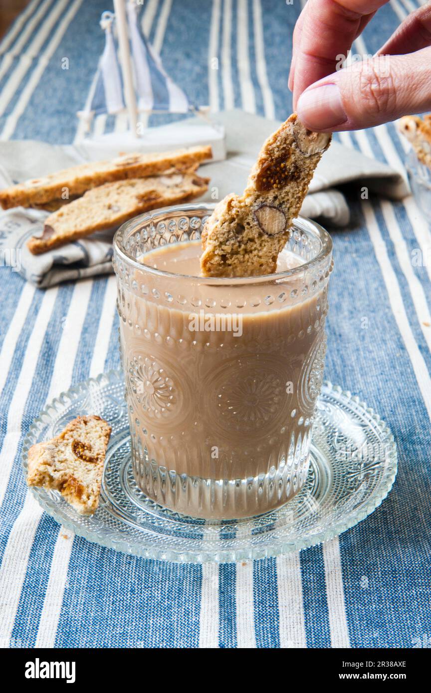 Biscotti with figs and nuts being dipped into coffee Stock Photo - Alamy
