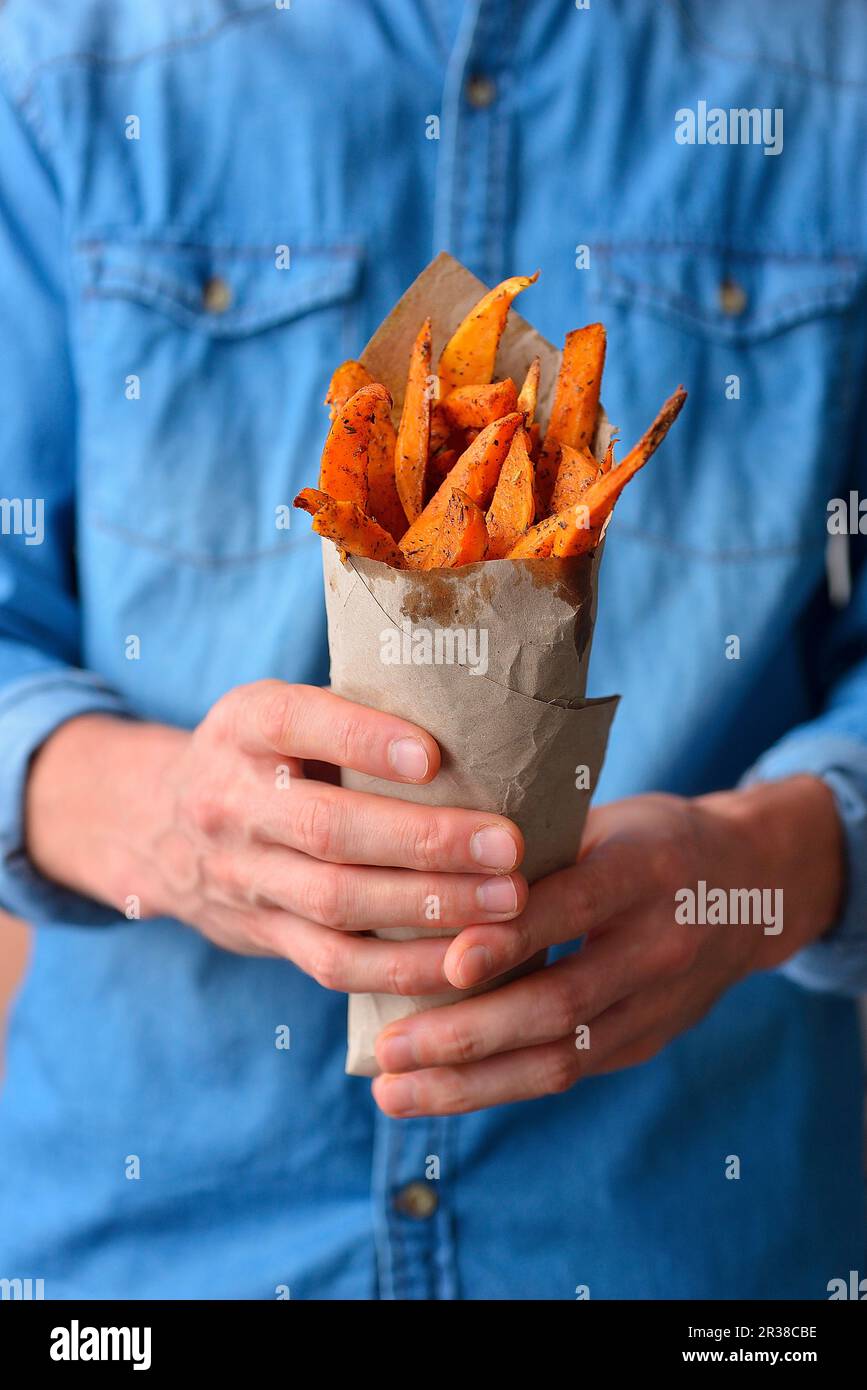 Man holds in his hands the fries of the sweet potato Stock Photo - Alamy